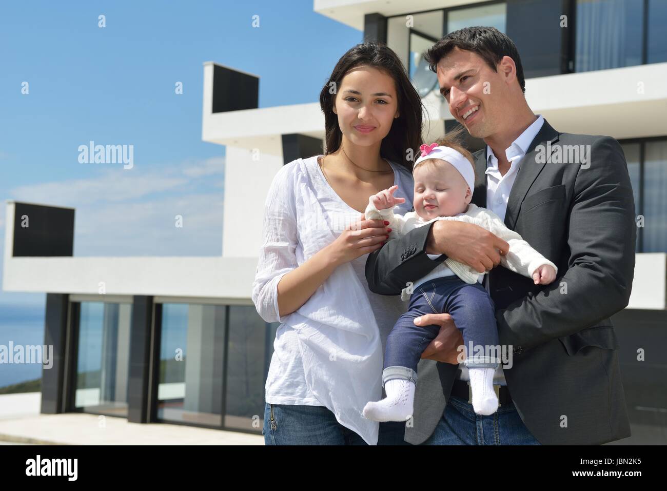 happy young family couple with beautiful new born baby have fun at home ...