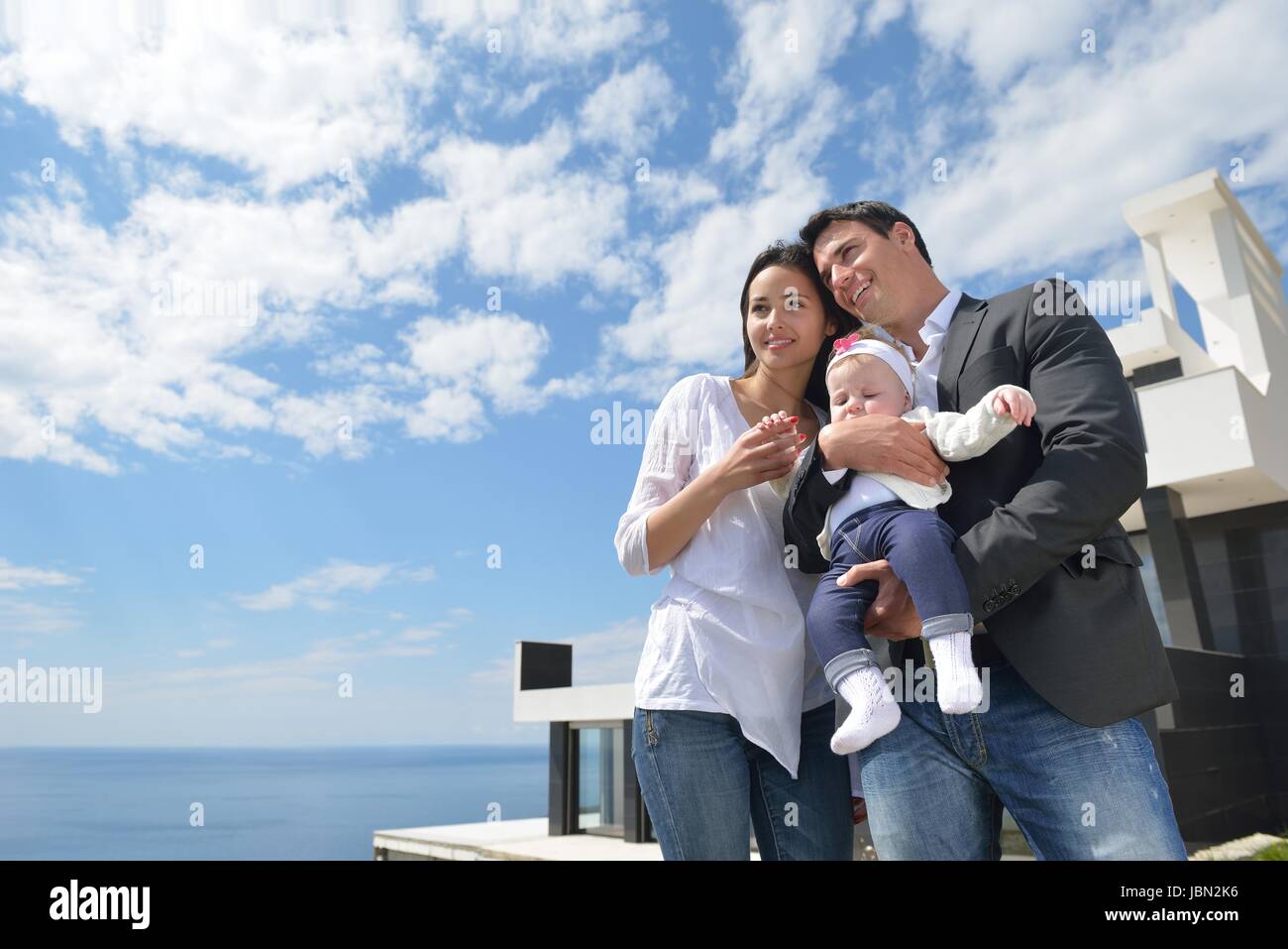 happy young family couple with beautiful new born baby have fun at home ...