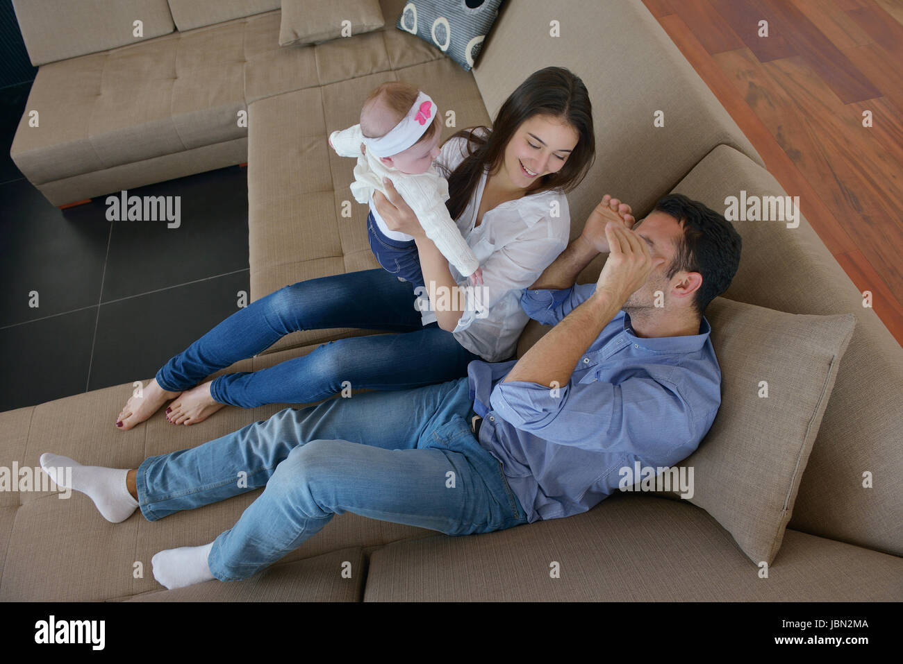 happy young family couple with beautiful new born baby have fun at home ...