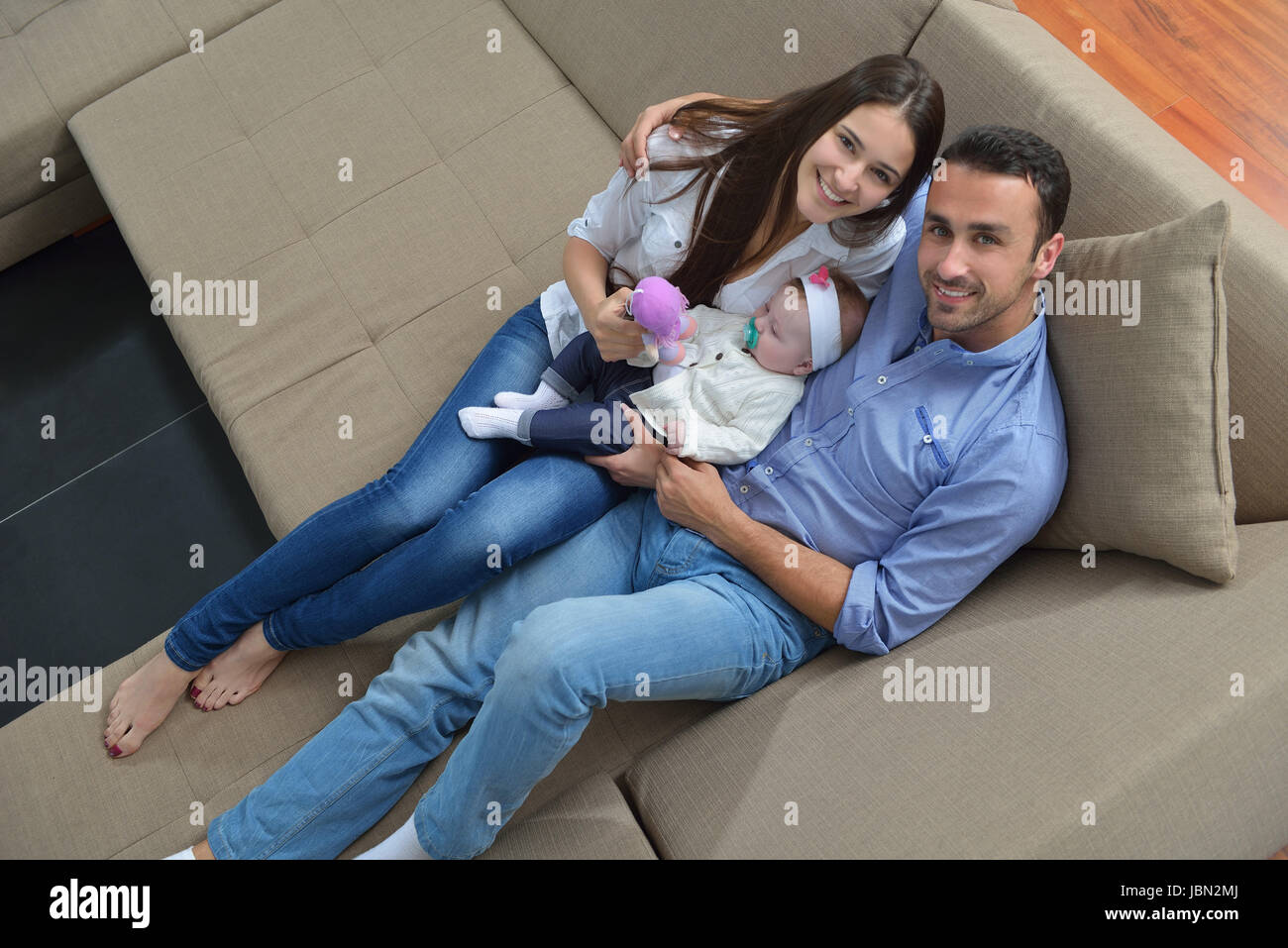 happy young family couple with beautiful new born baby have fun at home ...