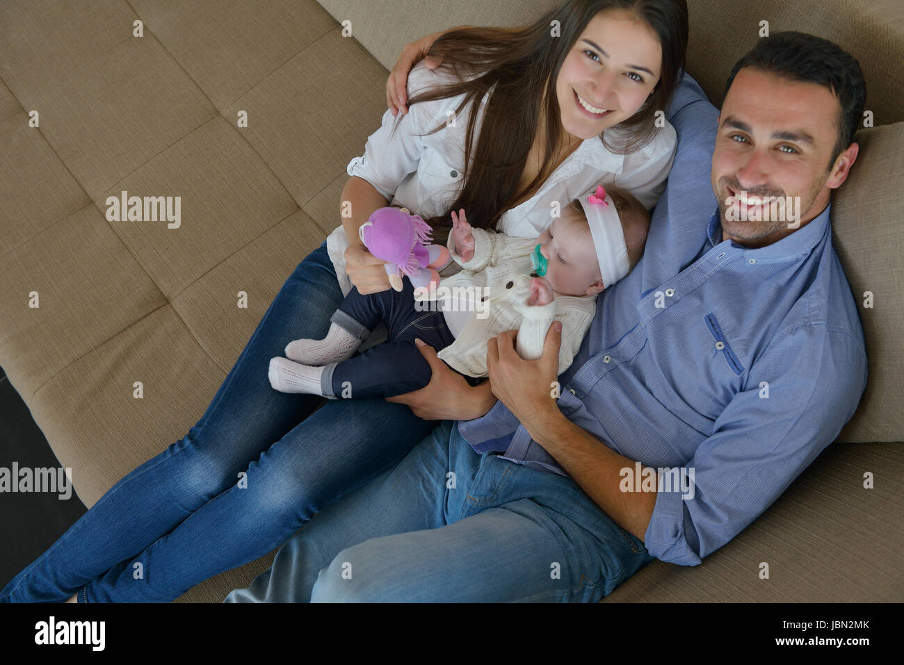 happy young family couple with beautiful new born baby have fun at home ...