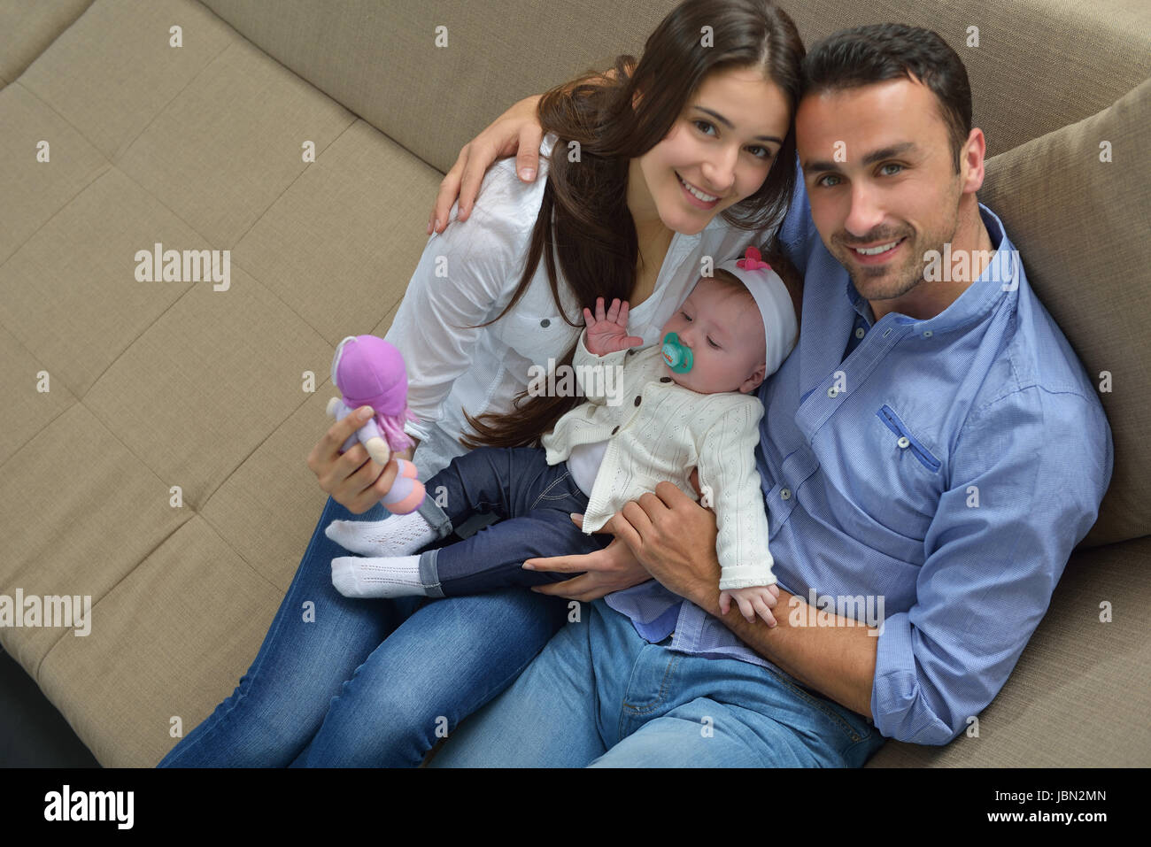 happy young family couple with beautiful new born baby have fun at home ...
