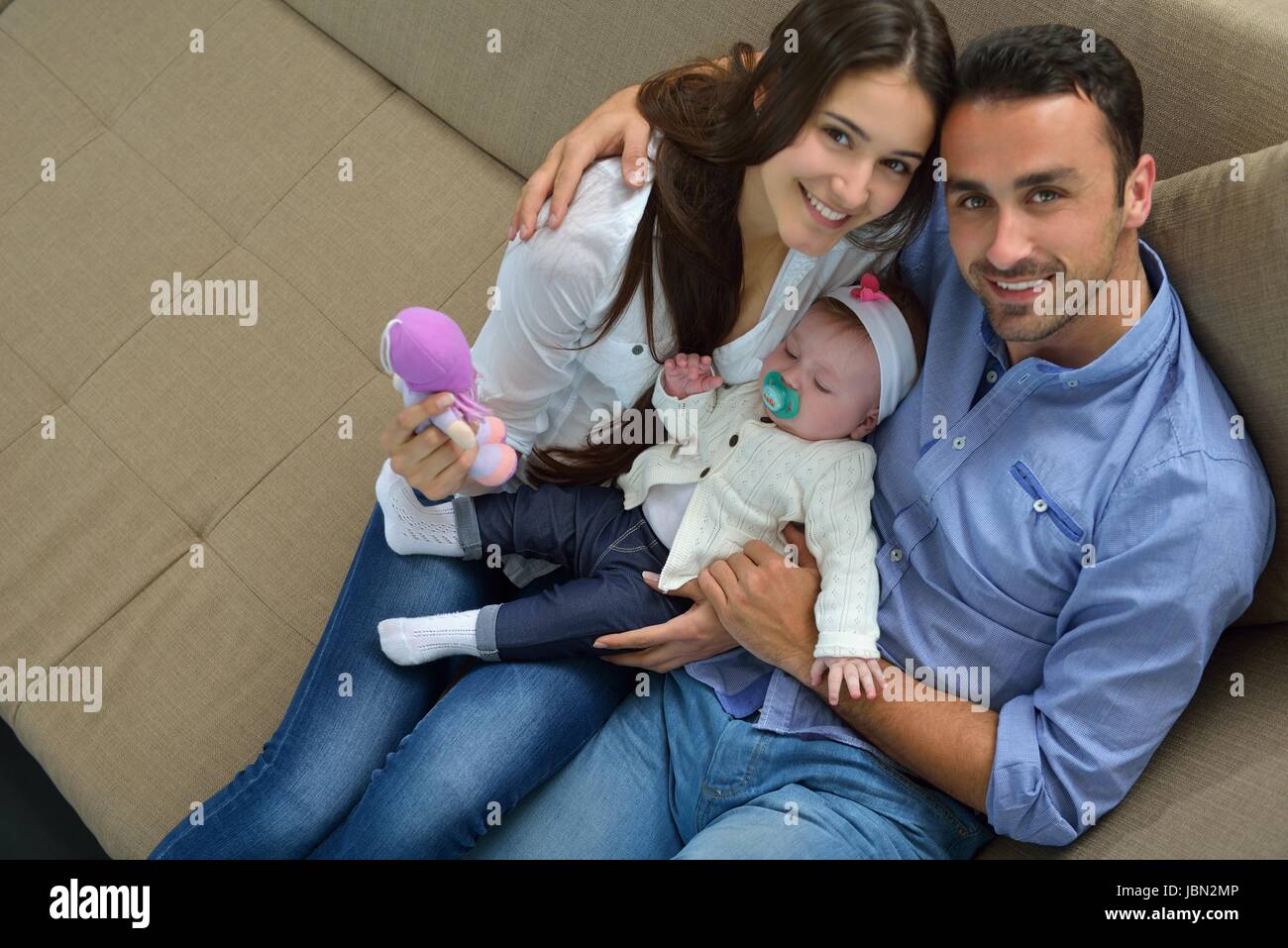 happy young family couple with beautiful new born baby have fun at home ...