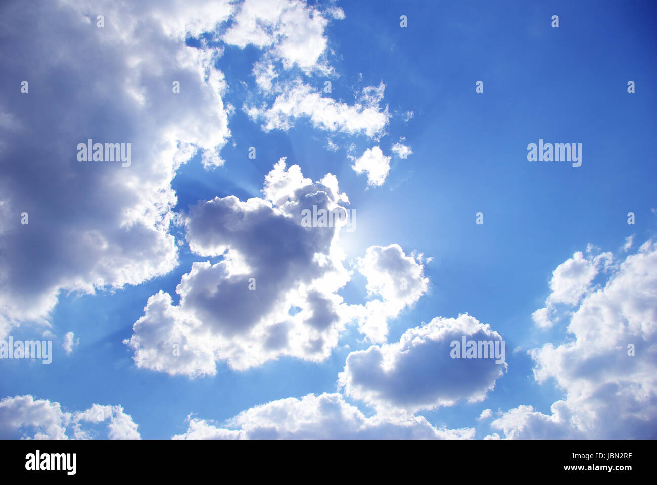 sun in a blue cloudy sky Stock Photo - Alamy