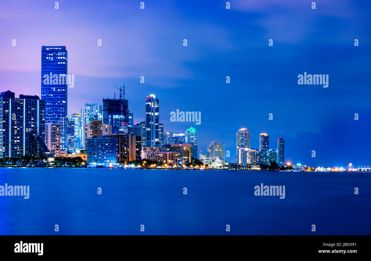 Miami city skyline panorama at dusk with urban skyscrapers over sea ...