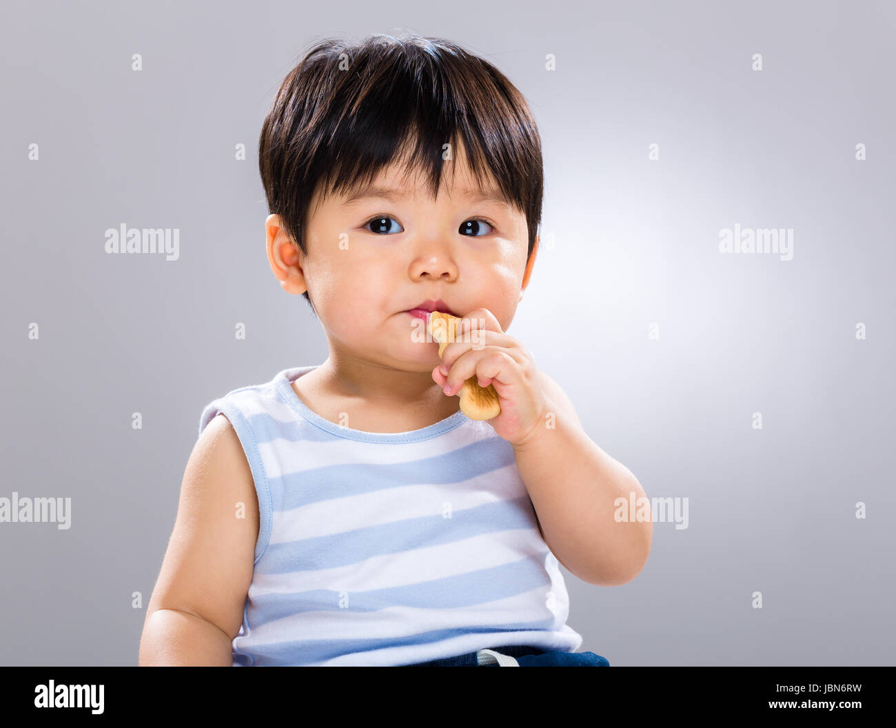 Little boy eating biscuit Stock Photo - Alamy