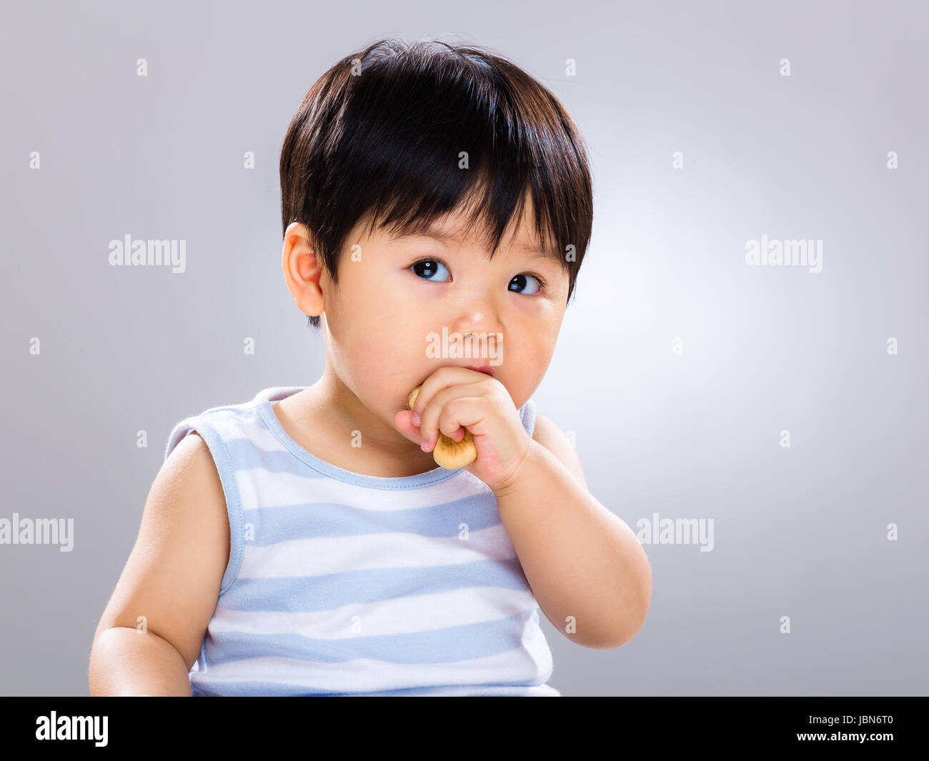 Baby boy eating biscuit Stock Photo - Alamy