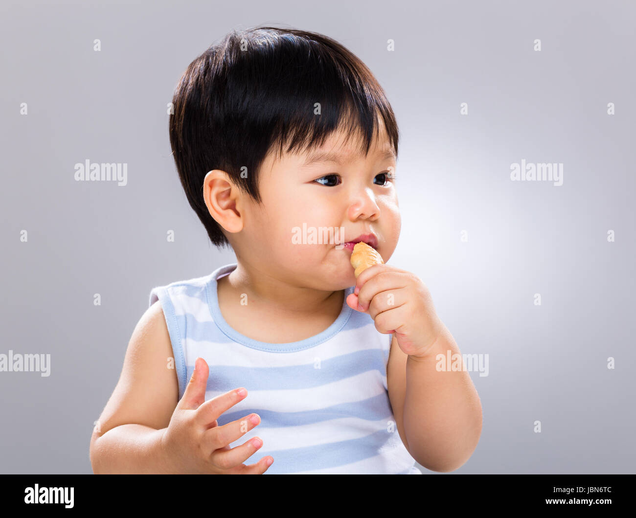 Baby boy eating biscuit Stock Photo - Alamy
