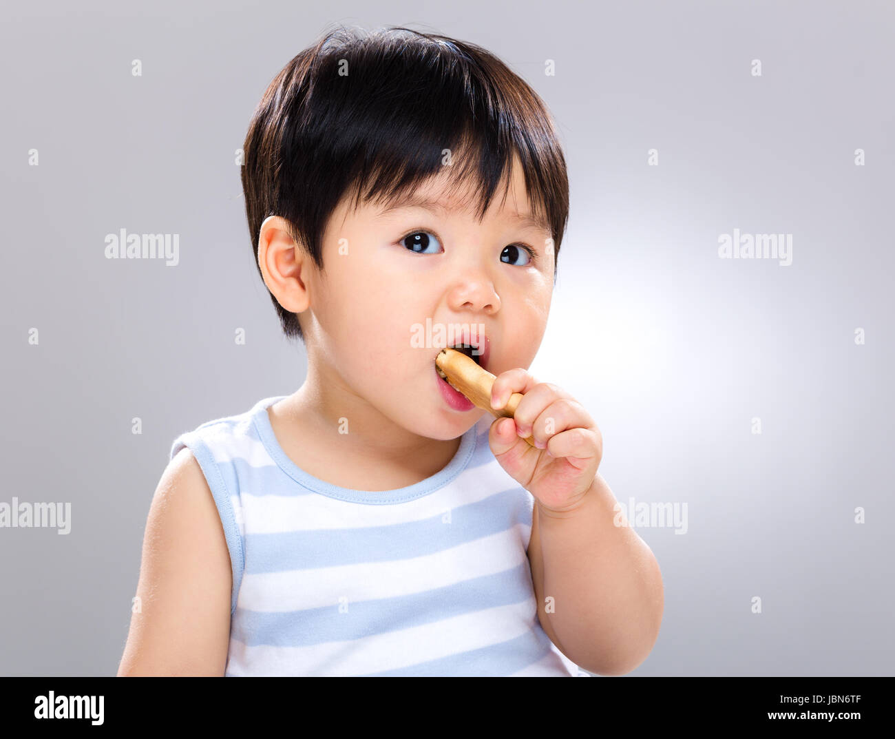 Baby eating biscuit Stock Photo - Alamy