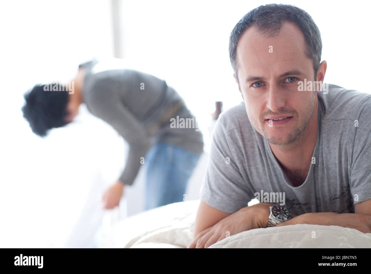 young man in bedroom at home thinking Stock Photo - Alamy