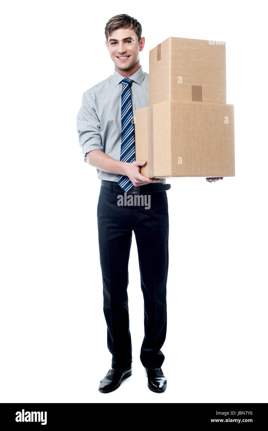 Smiling young corporate man holding stack of boxes Stock Photo - Alamy