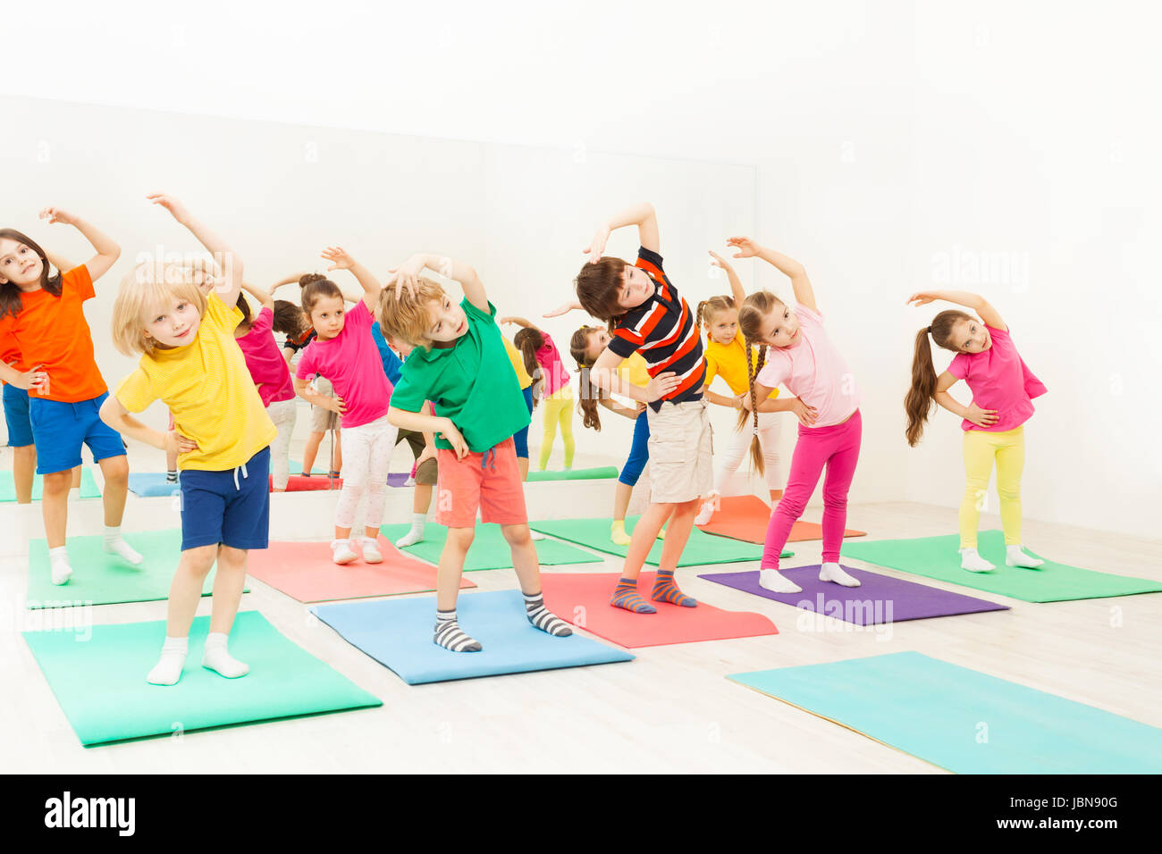Group of happy kids, 5-6 years old girls and boys, doing side bending ...