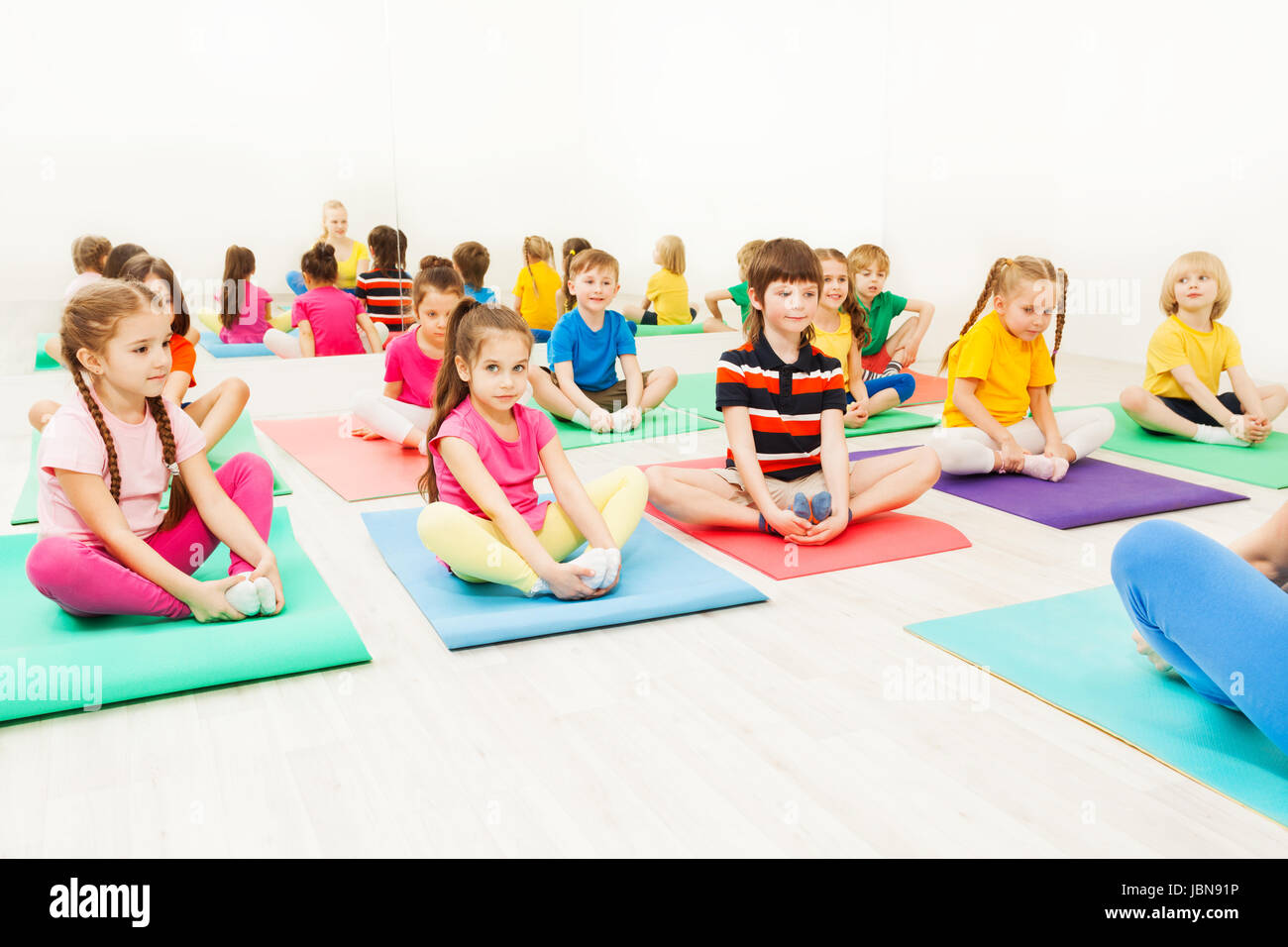 Portrait of 5-6 years old boys and girls doing butterfly exercise ...