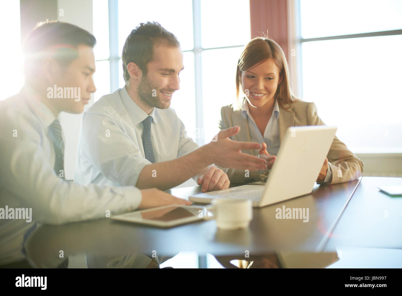 Portrait of smart business partners discussing computer project at ...