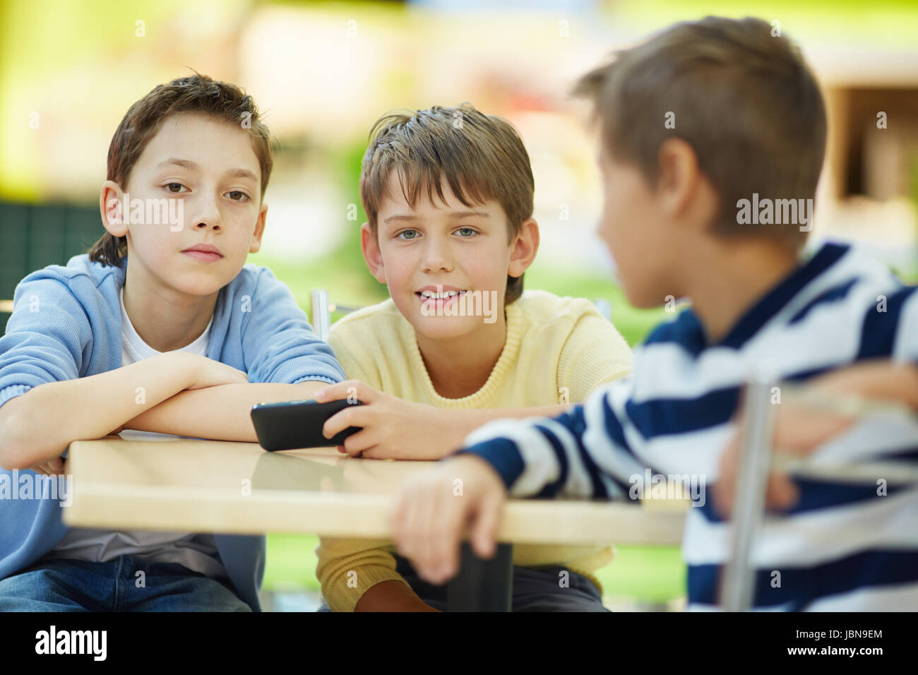 Three boys talking indoors Stock Photo - Alamy