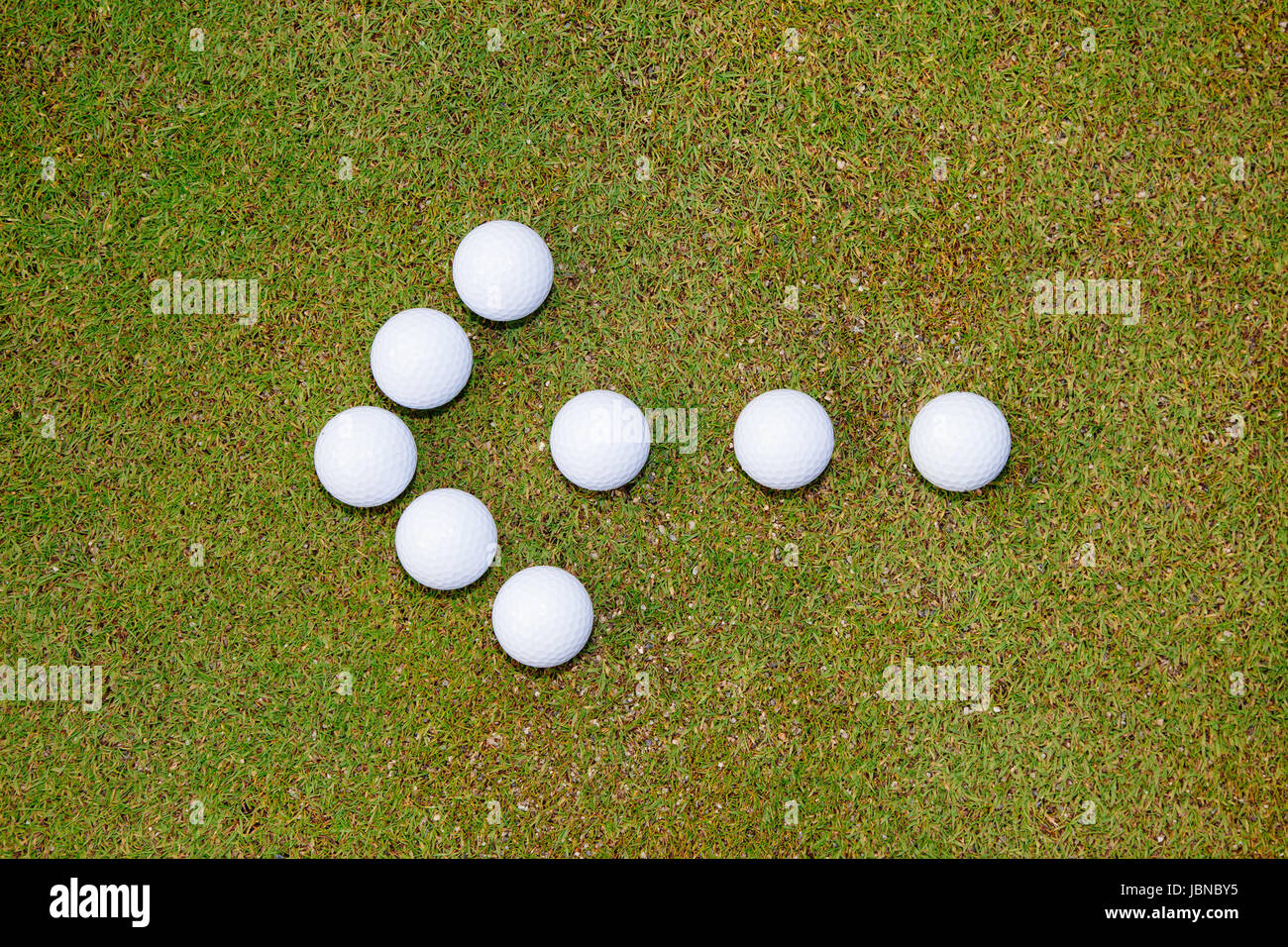 Arrow sign made with golf ball on grassy field of golf course Stock ...
