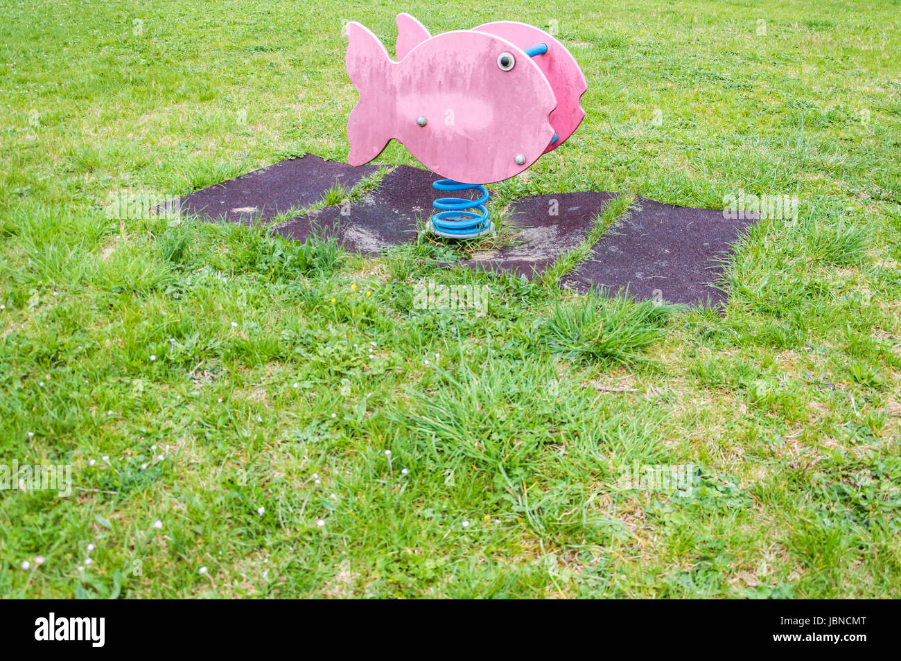 Old pink playground springer fish riding toy Stock Photo - Alamy