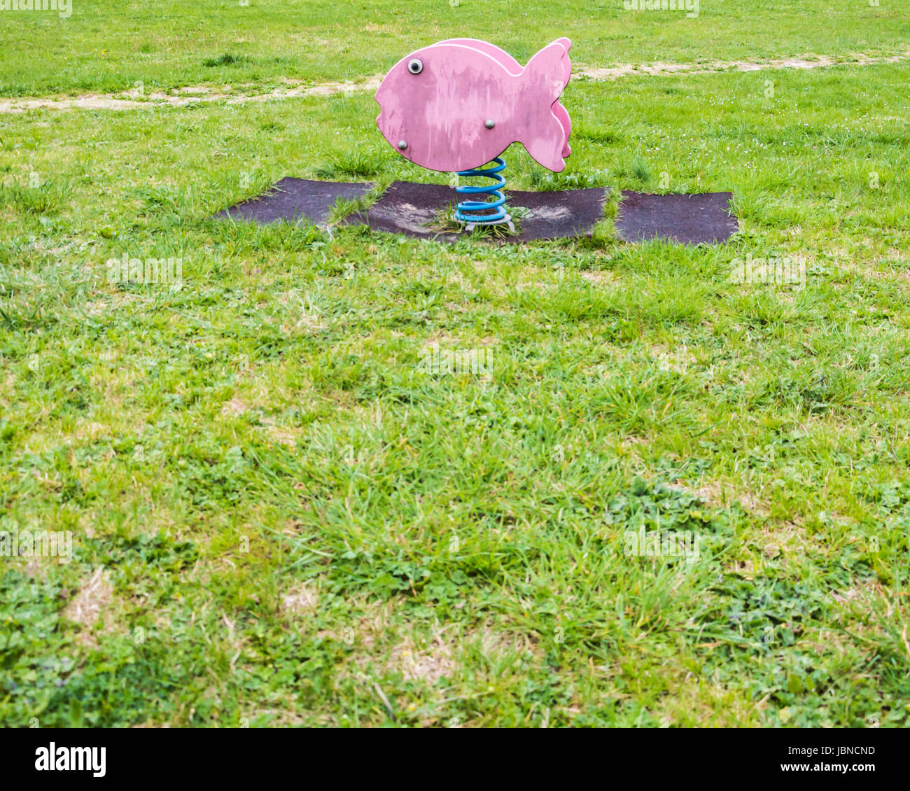 Old pink playground springer fish riding toy Stock Photo - Alamy