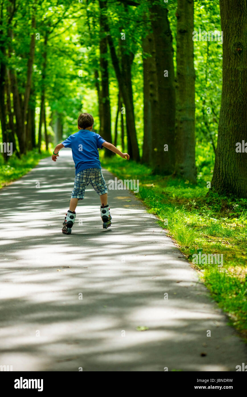 boy on inline skates, rolling through the park Stock Photo - Alamy