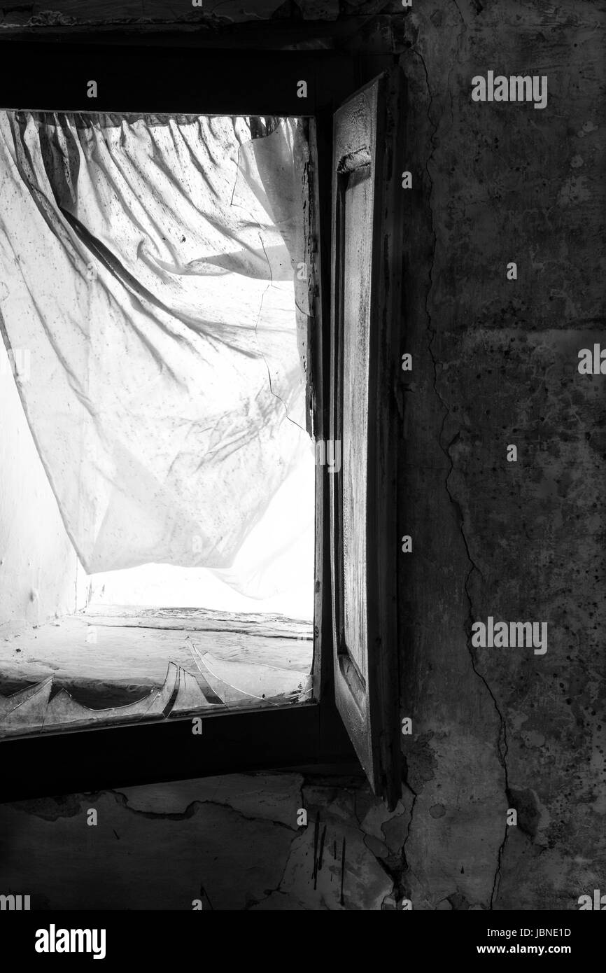 The Window-- A broken window in an abandoned house.A cotton curtain ...