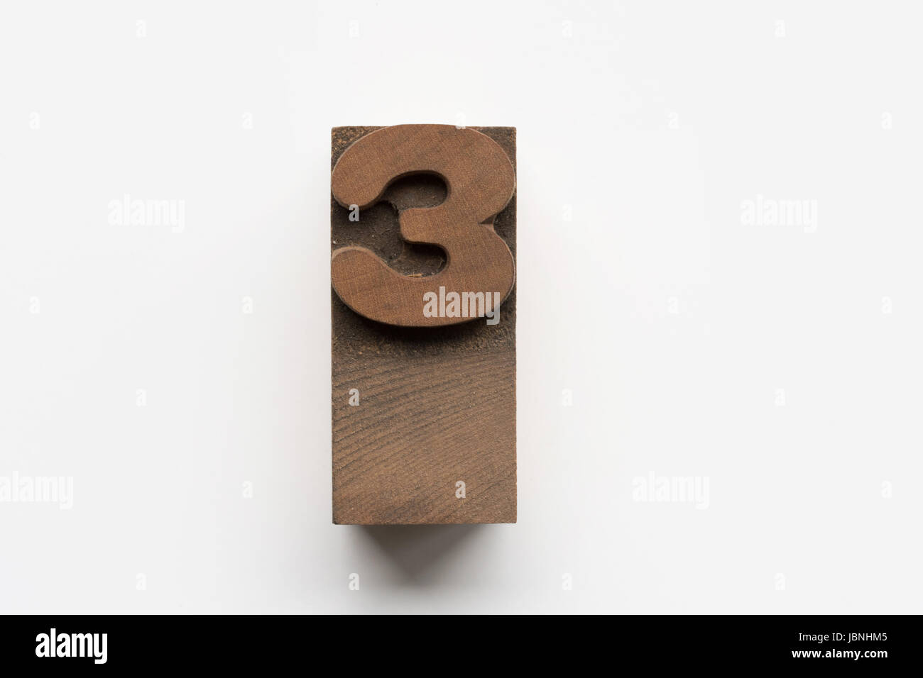 Old letterpress number 3 printing block isolated on a white background ...