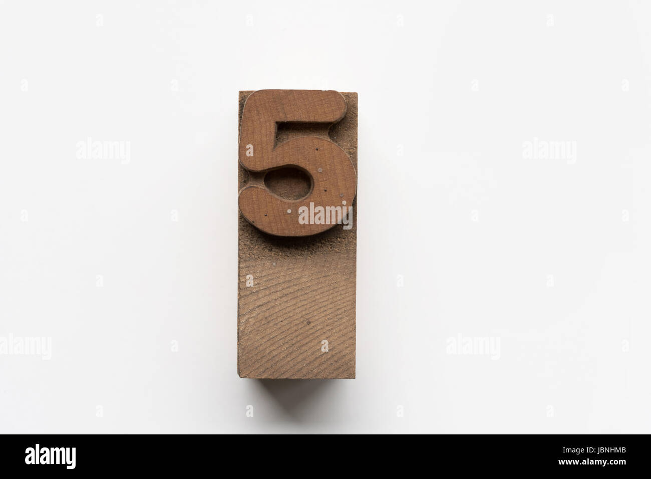 Old letterpress number 5 printing block isolated on a white background ...