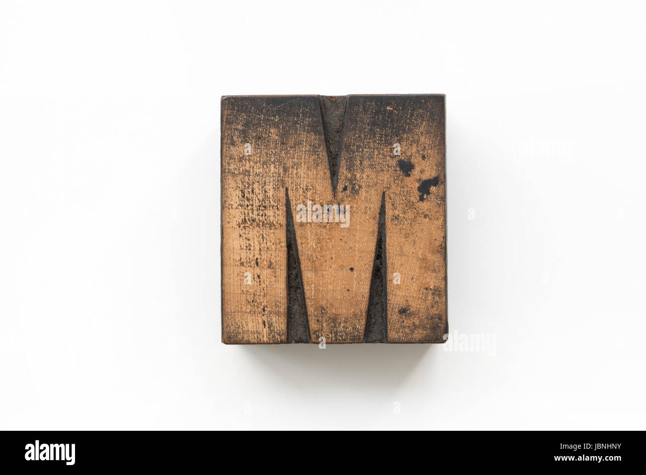 Old letterpress letter m printing block isolated on a white background ...