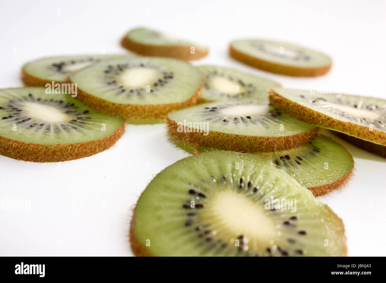 Kiwi green with black small bones. Pile on white background. Juicy in ...