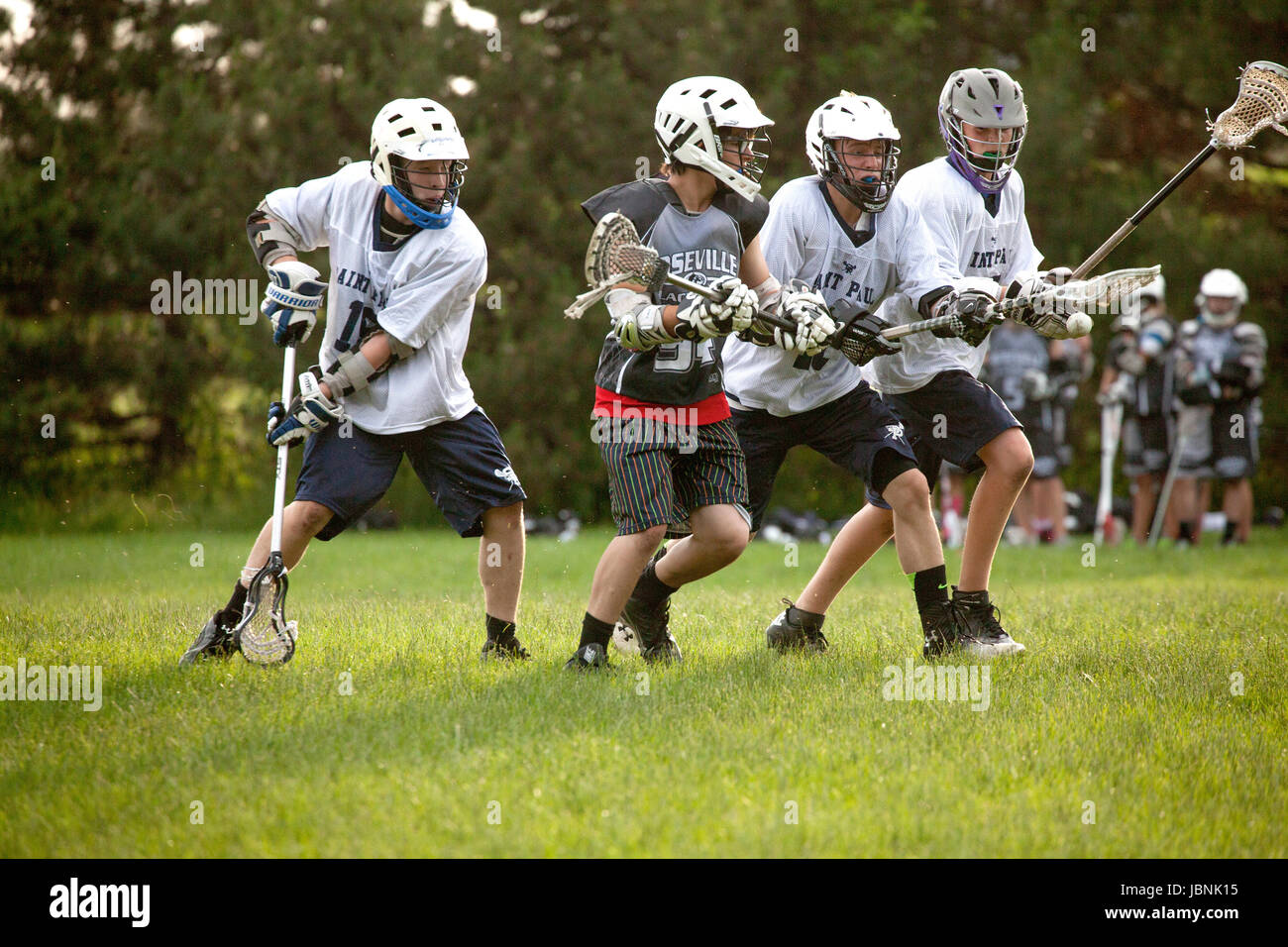 High school lacrosse players competing to get the ball in midair. St ...