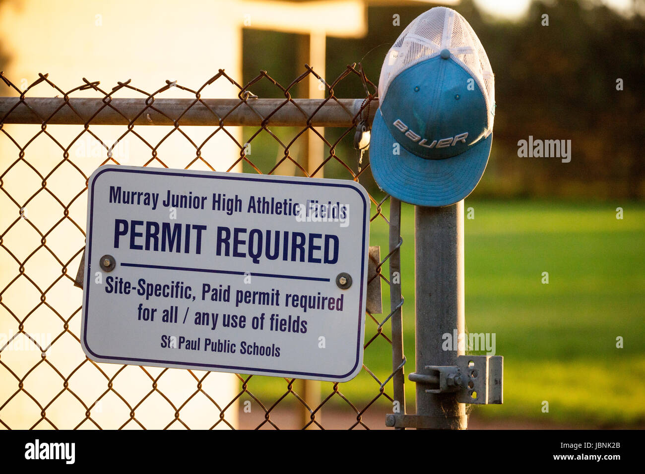 Sign for athletic field permit requirement and hat on a fence. St Paul ...