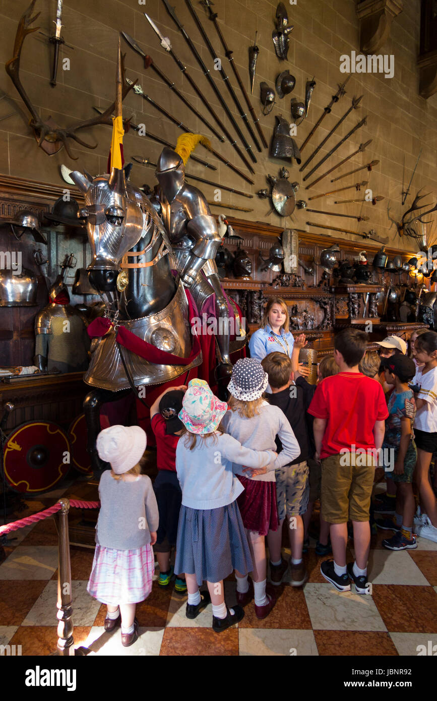 A tour guide talks about a display of armoury / armour to a group of ...