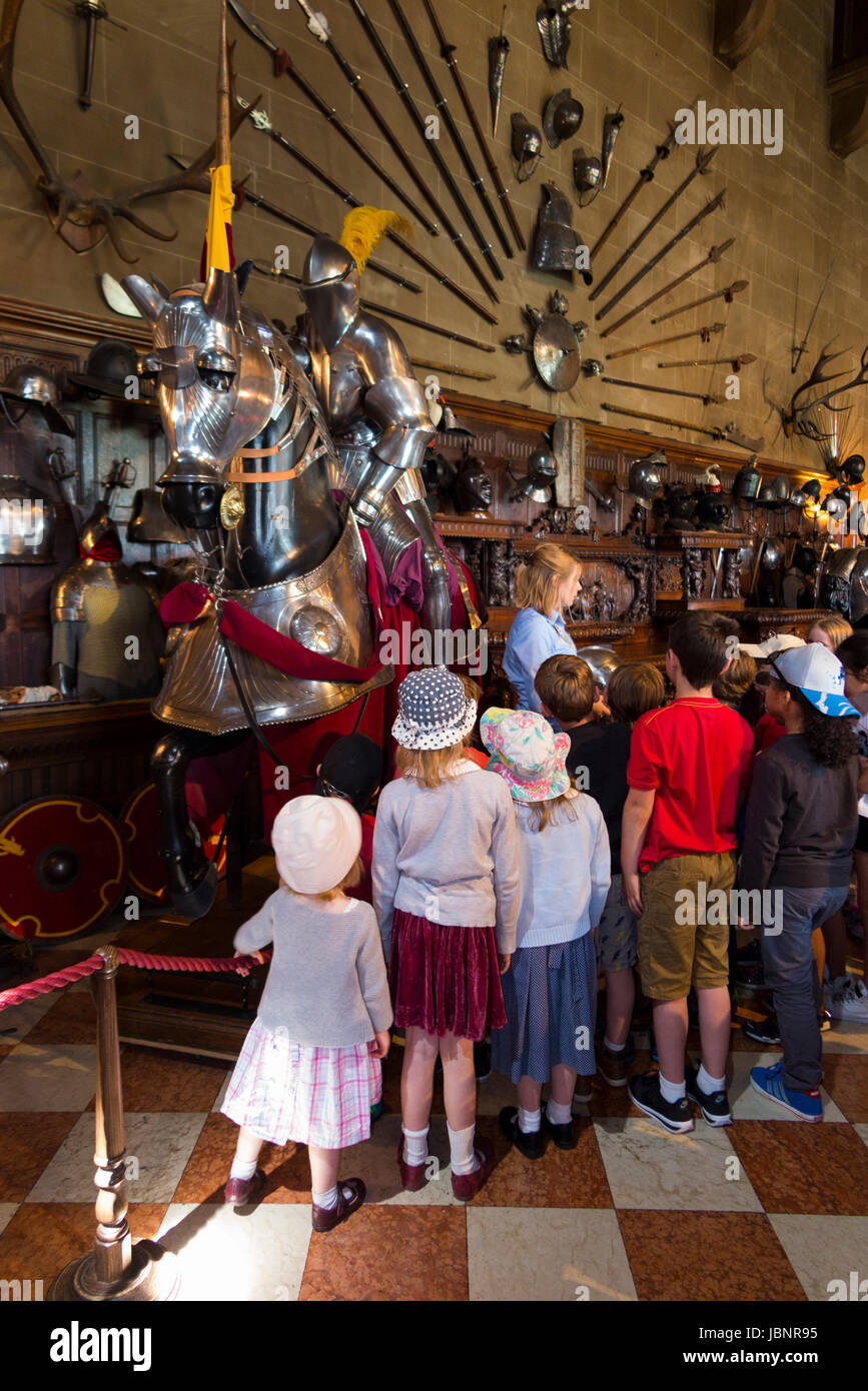 A tour guide talks about a display of armoury / armour to a group of ...