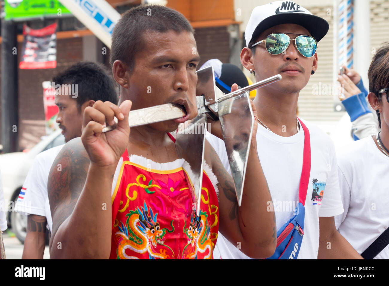 Man with cheeks pierced by anchor in a parade during the Nine Emperor ...
