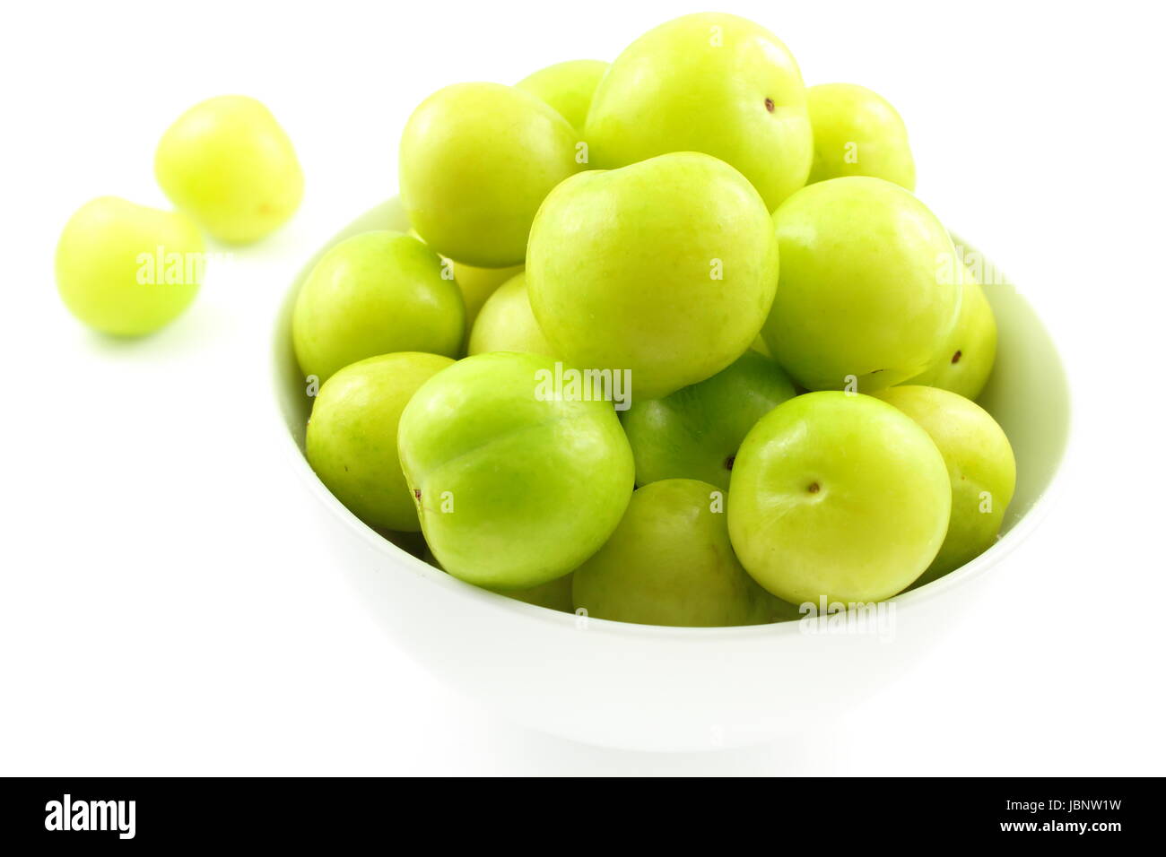 composition of fresh turkish can erik plum fruits in a small white bowl ...