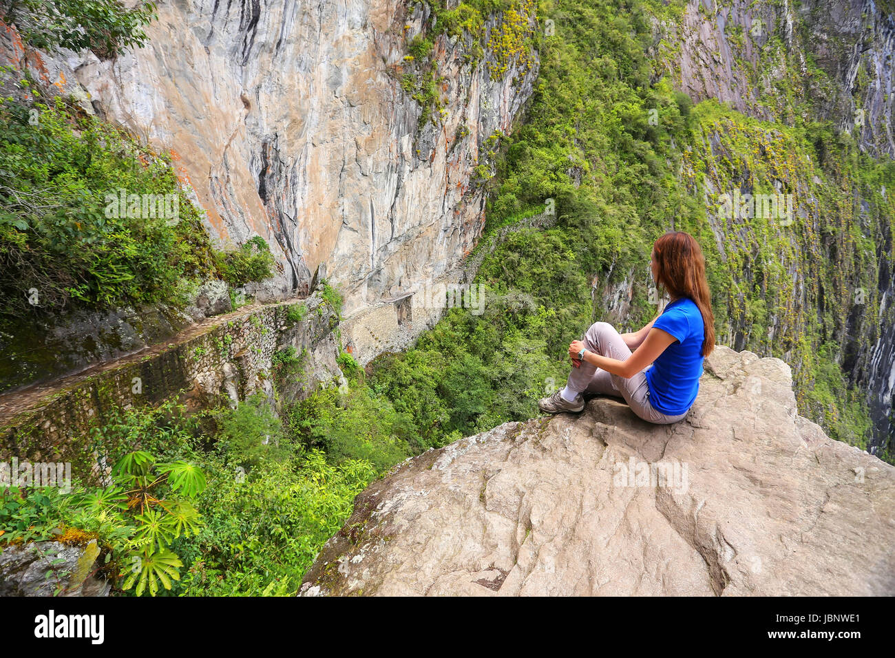Young woman enjoying the view of Inca Bridge and cliff path near Machu ...