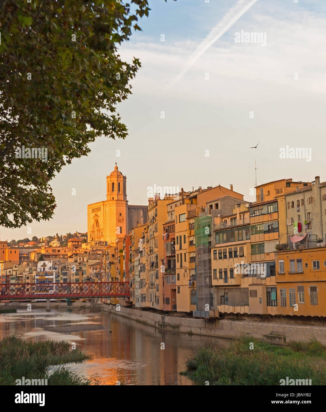 Onyar river crossing the downtown of Girona with bell tower of Basilica ...