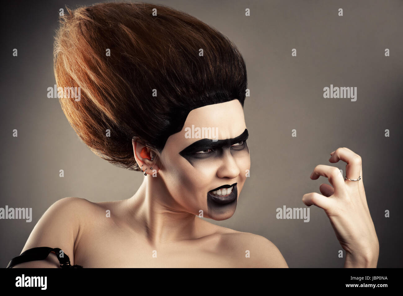 angry brunette woman with dark makeup and lush hairdo Stock Photo - Alamy