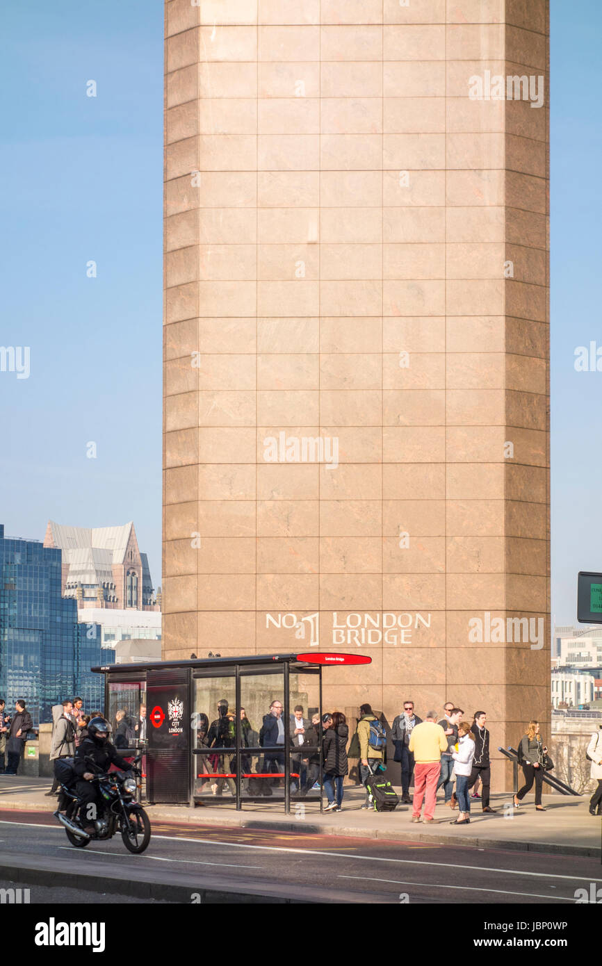People waiting at a bus stop outside No.1 London Bridge, London Bridge ...