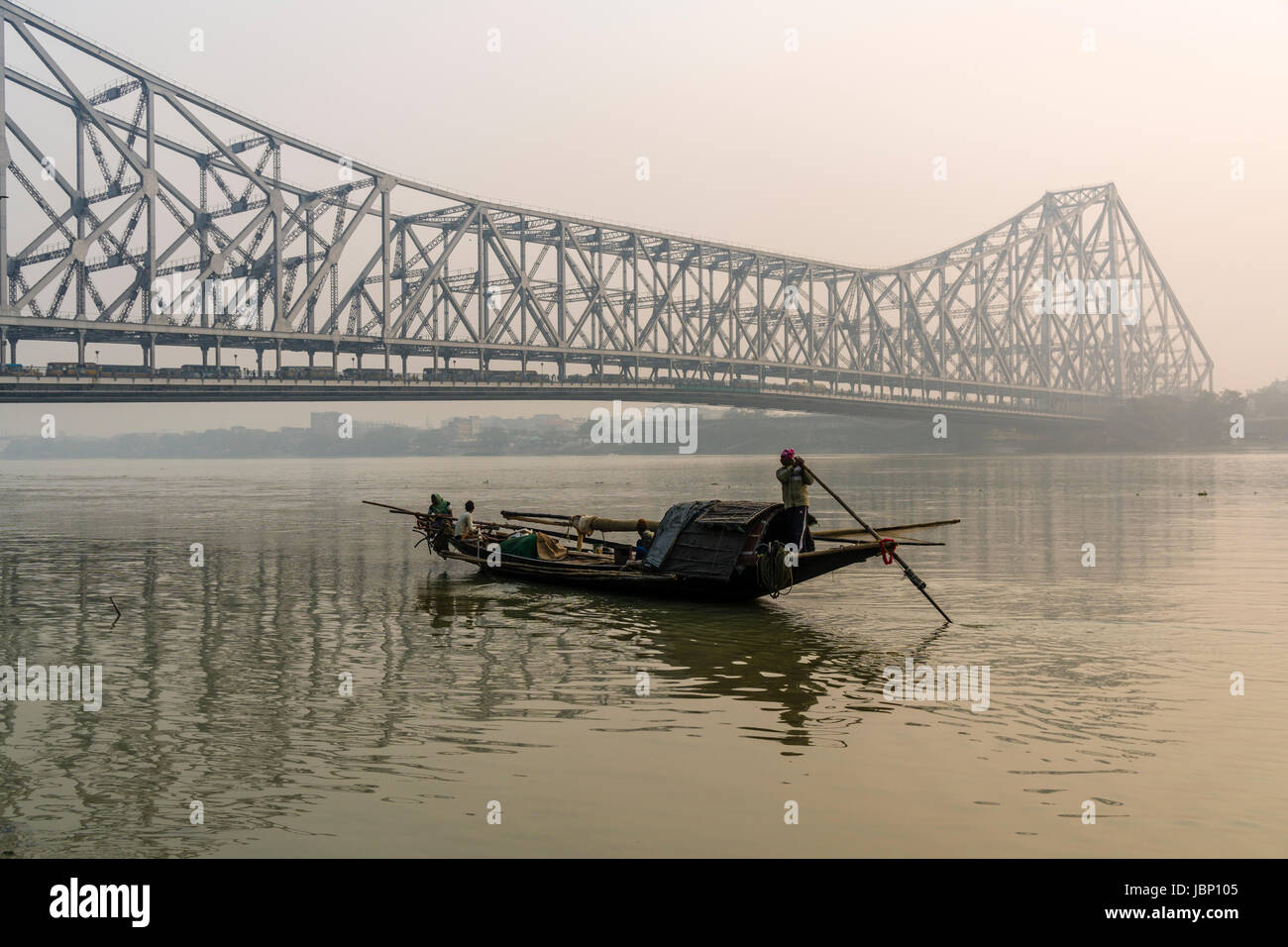 The steel construction of Howrah Bridge in Kolkata, a fishermans boat ...