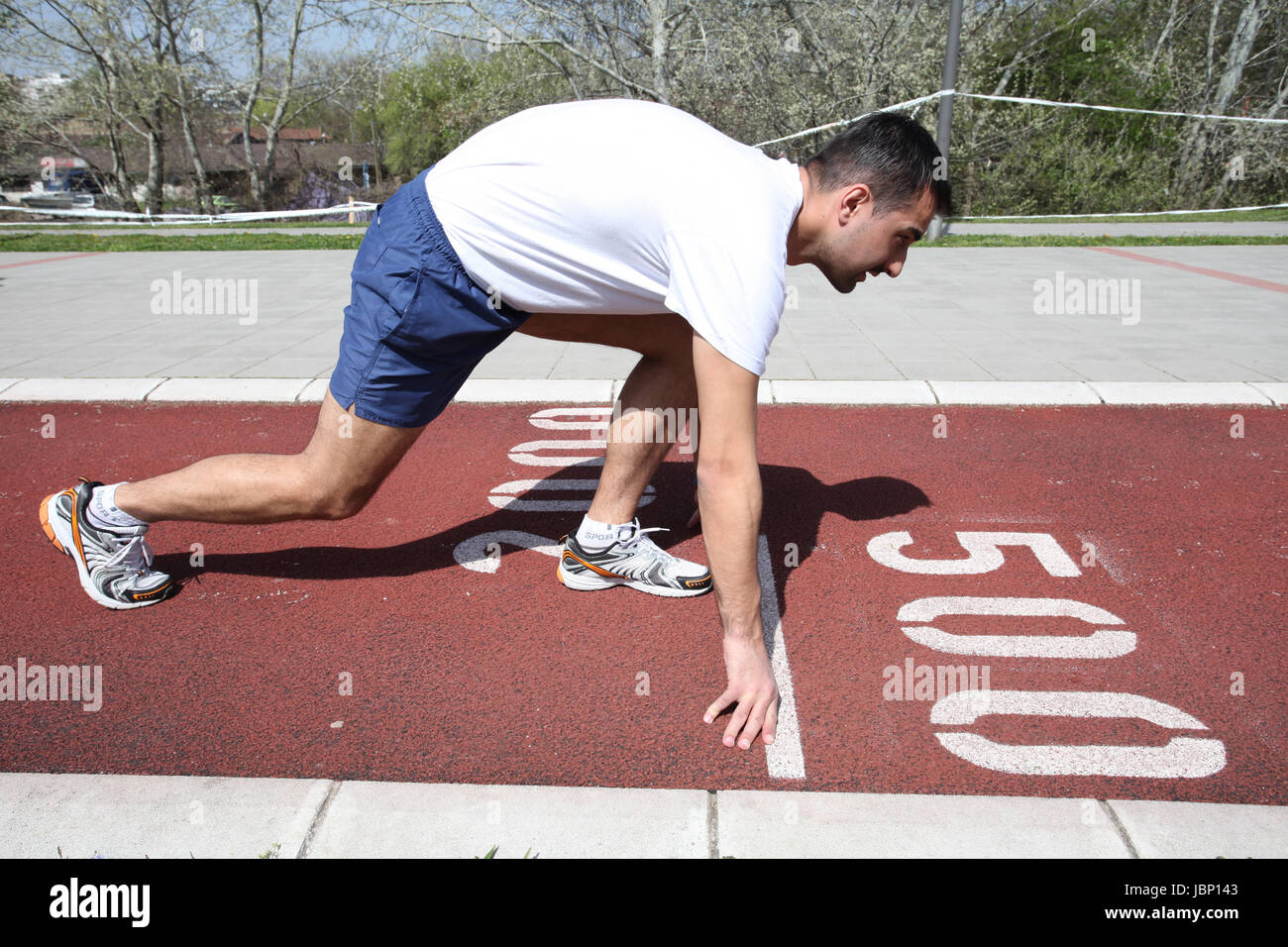 Athlete on starting line waiting for the start in running track Stock ...