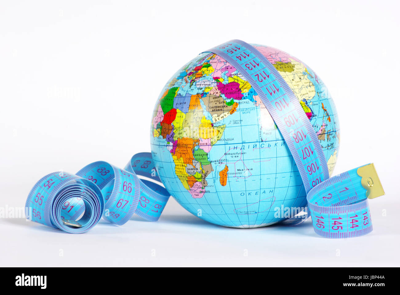 Measuring tape stretched across globe on white Stock Photo - Alamy
