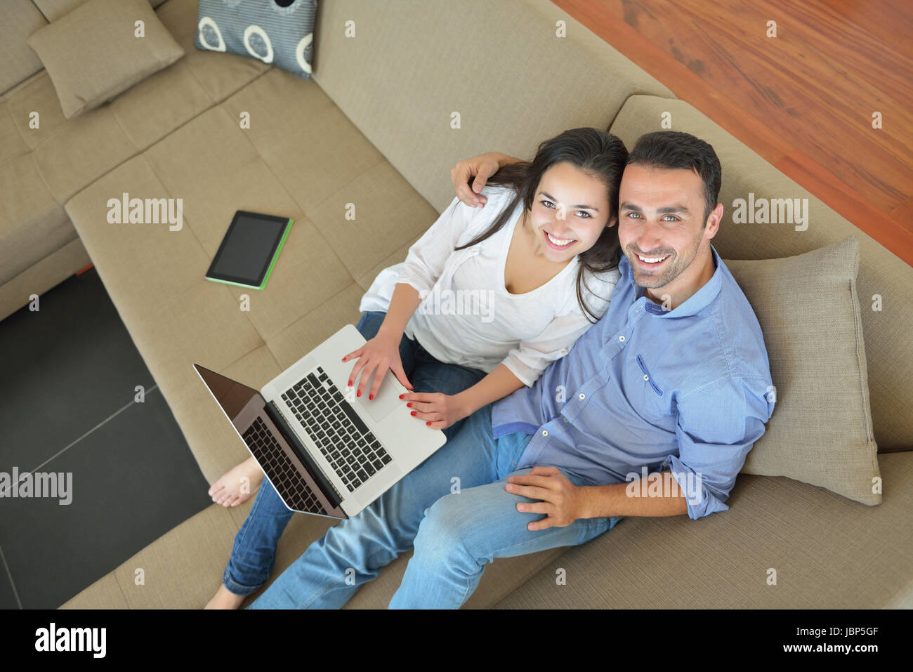 happy young relaxed couple working and playing on laptop computer at ...