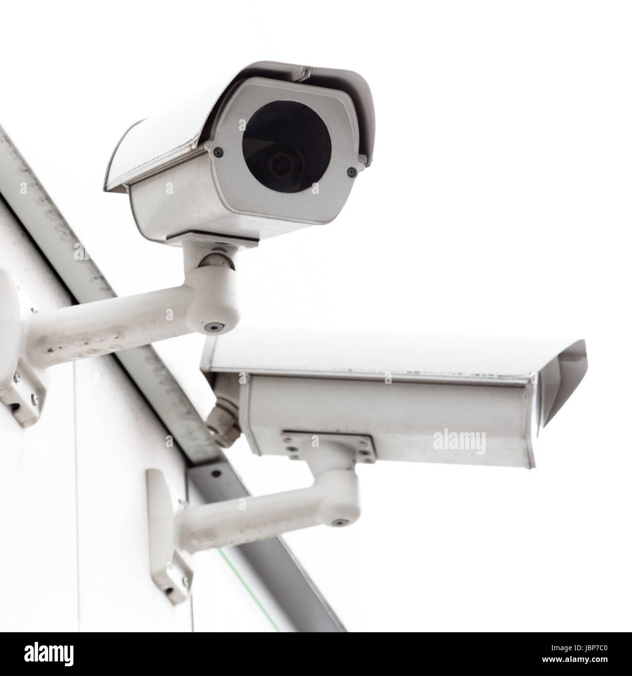 Security cameras mounted on a white wall Stock Photo - Alamy