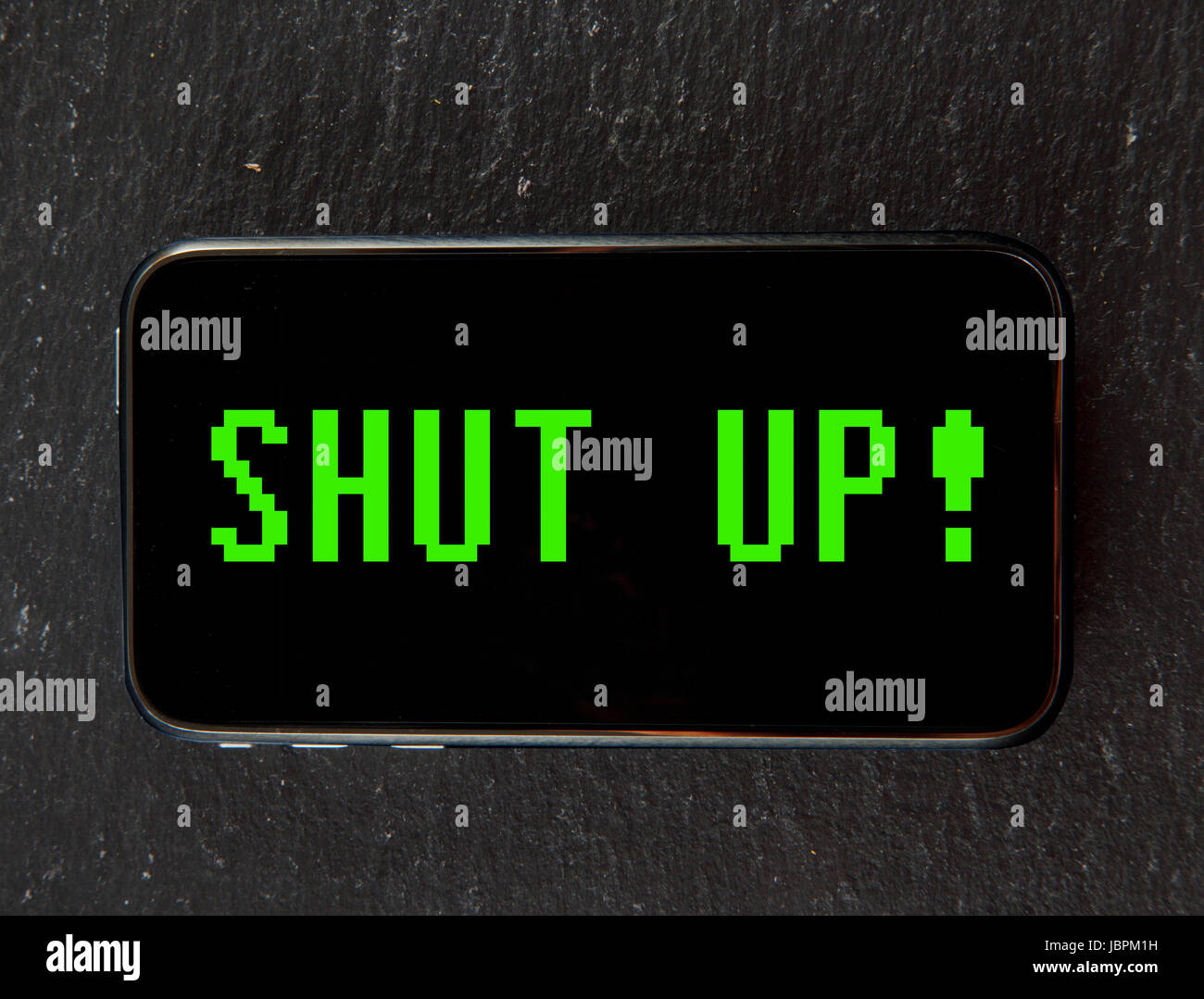 Smartphone with text "Shut up" in vintage computer font Stock Photo - Alamy
