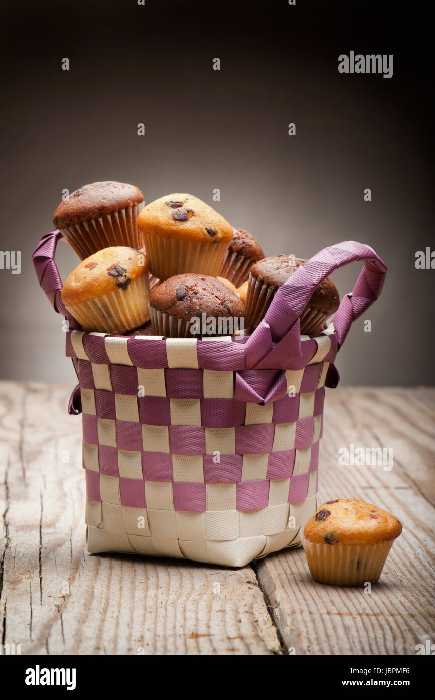 colorful basket full of little muffins variety on wooden table Stock ...