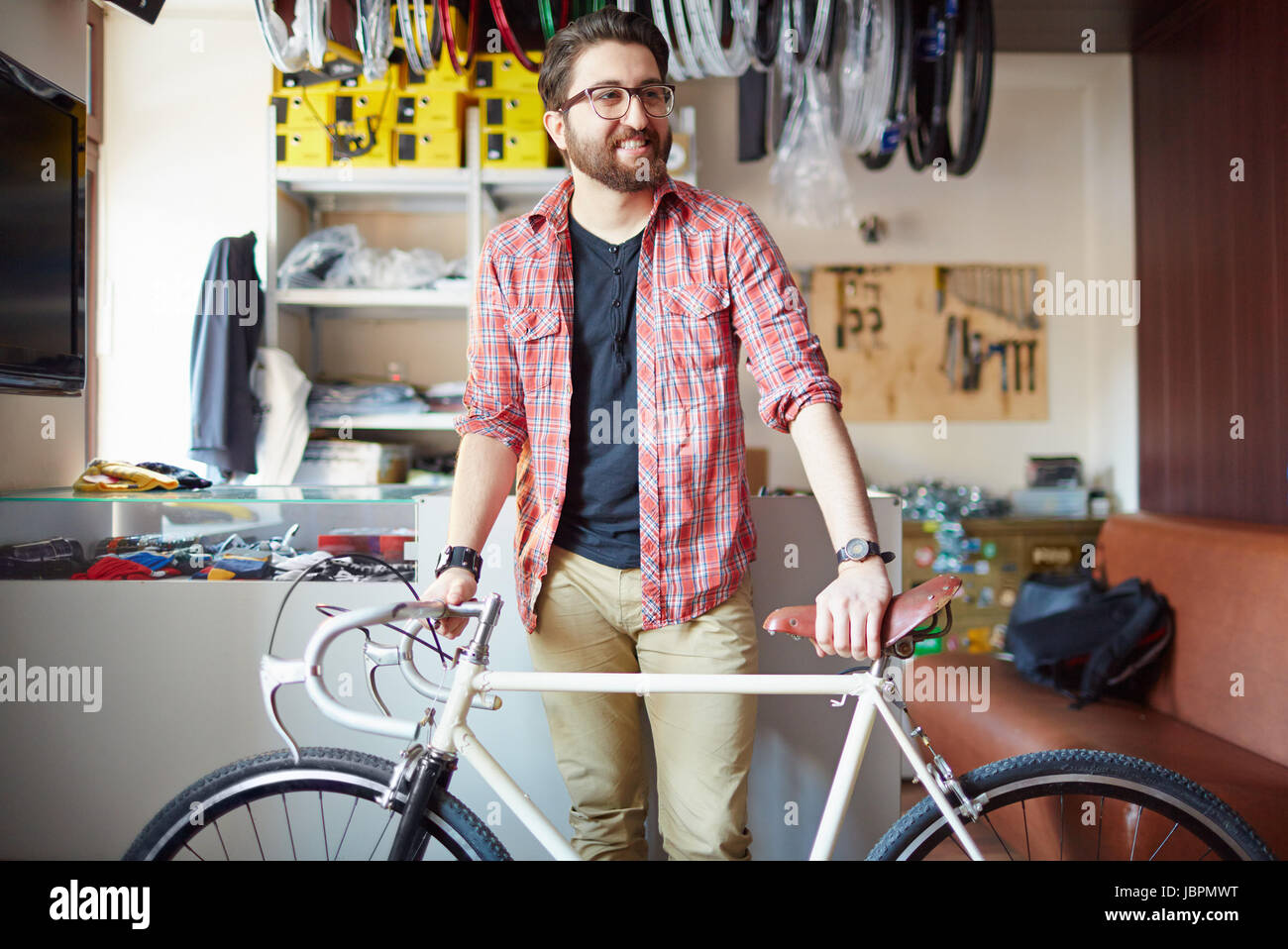 Portrait of a handsome man with bicycle in sports shop Stock Photo - Alamy