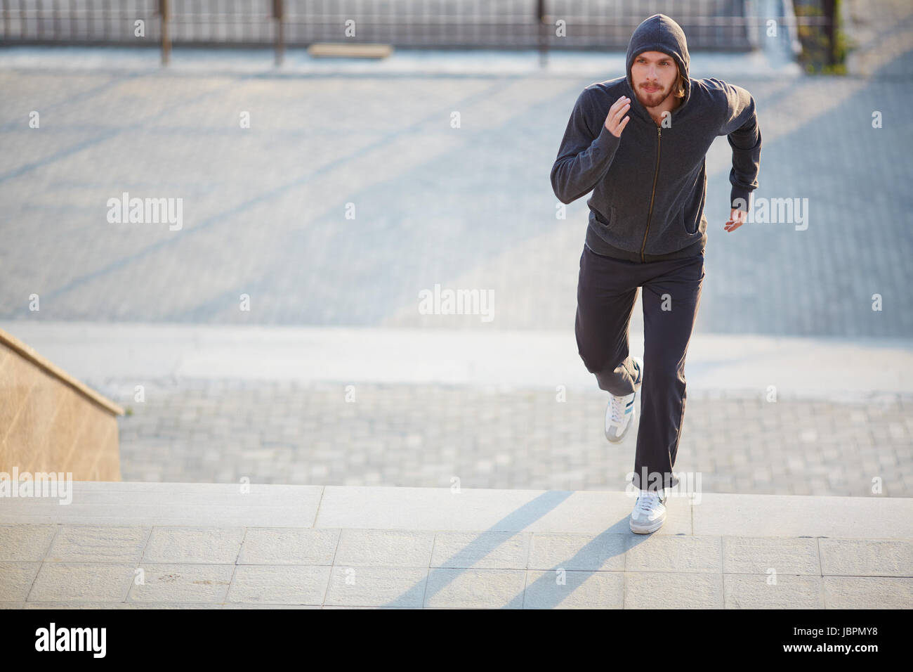 Portrait of young attractive sportsman running outside Stock Photo - Alamy