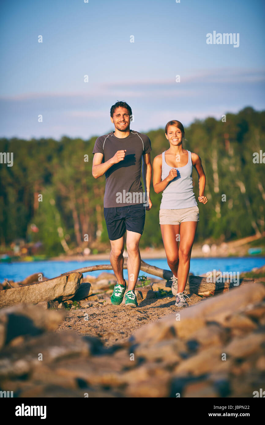 Photo of happy couple running outdoors Stock Photo - Alamy