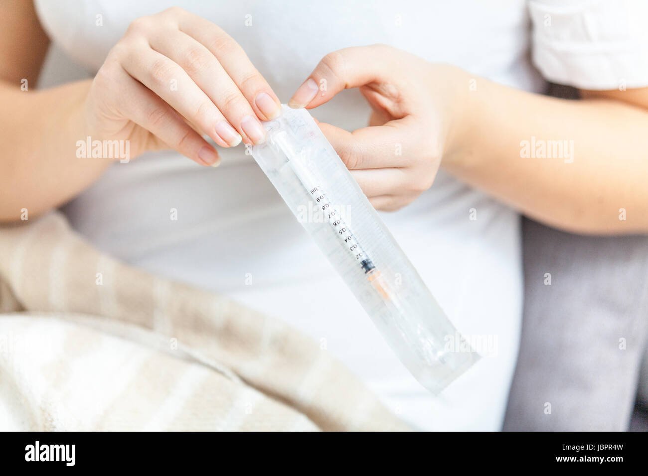 Closeup photo of syringe being unpacked Stock Photo - Alamy