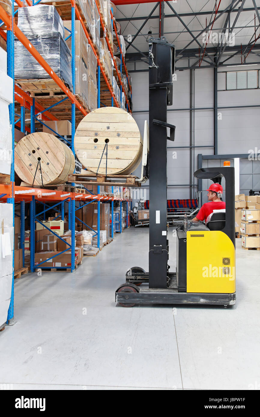 Forklift loading pallet with roll in distribution warehouse Stock Photo ...
